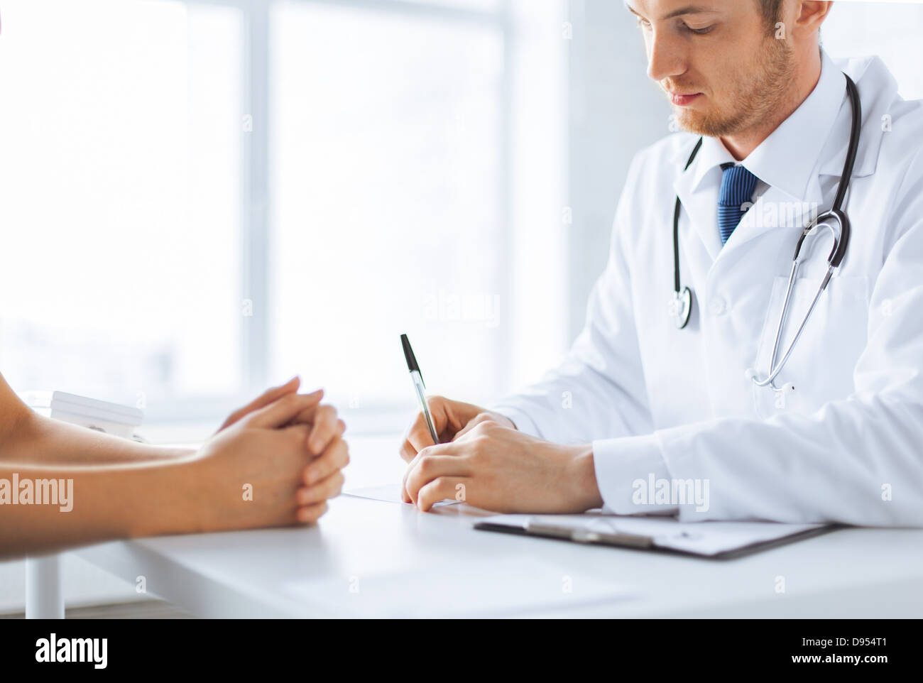 patient and doctor taking notes Stock Photo - Alamy