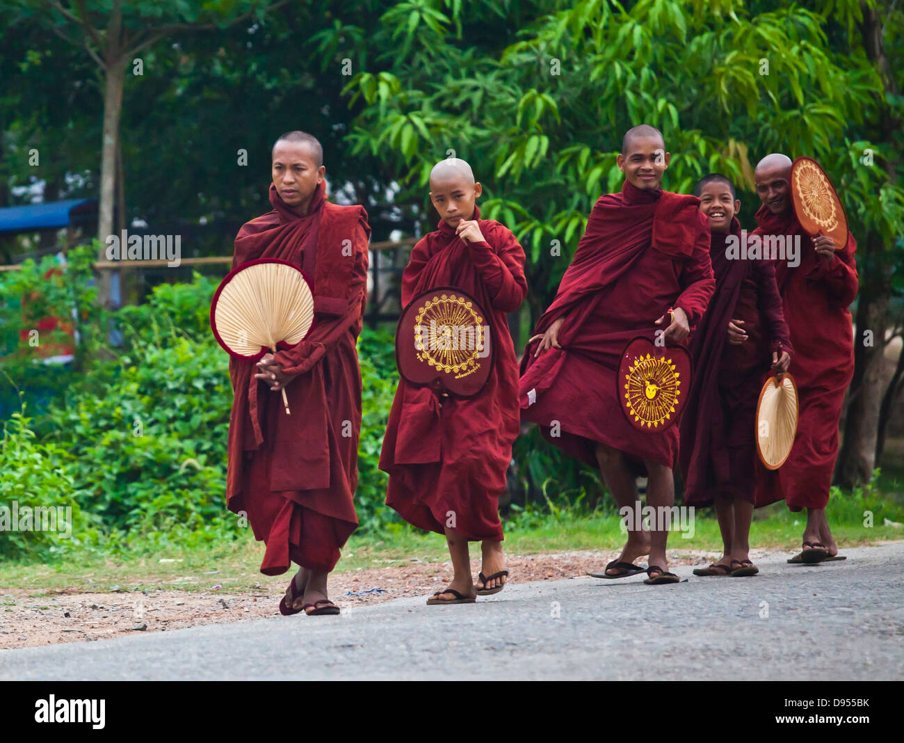 BUDDHIST MONKS with fans walk along the road - BAGO, MYANMAR Stock ...