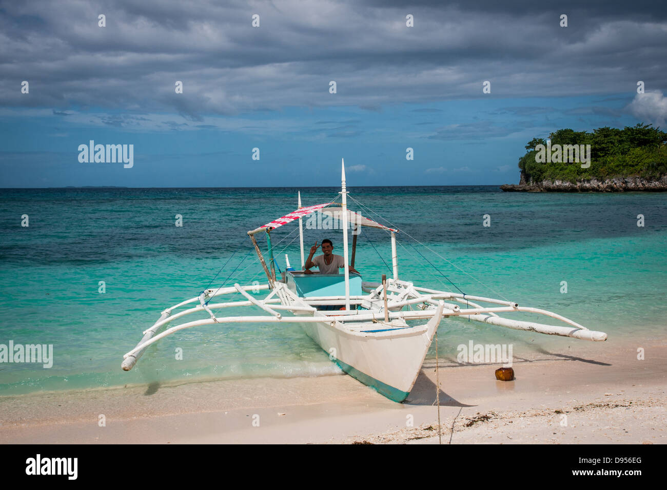 Traditional outrigger fishing boat moored on the beach at Malapascua ...