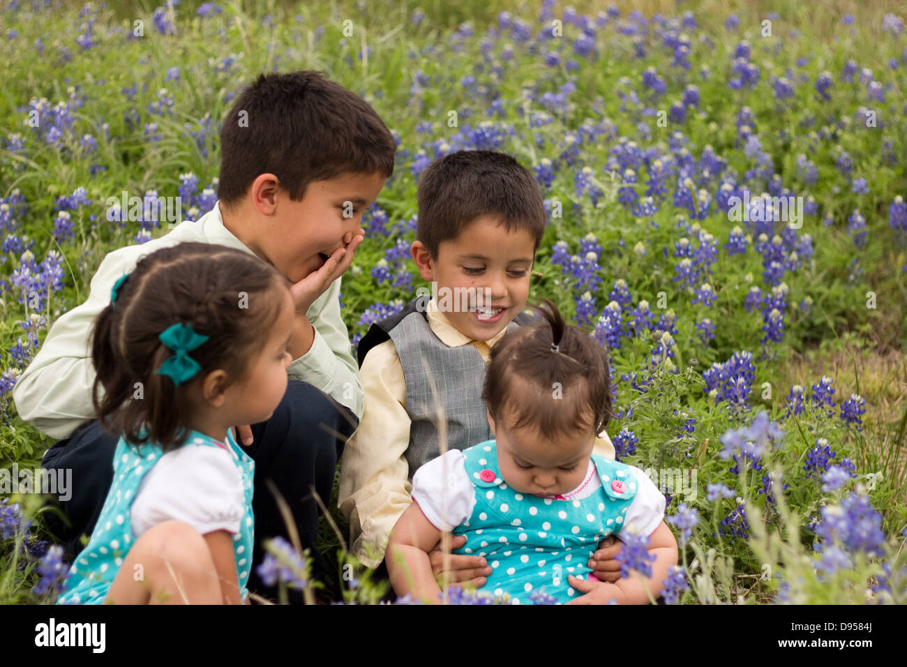 Four children playing in a field Stock Photo - Alamy