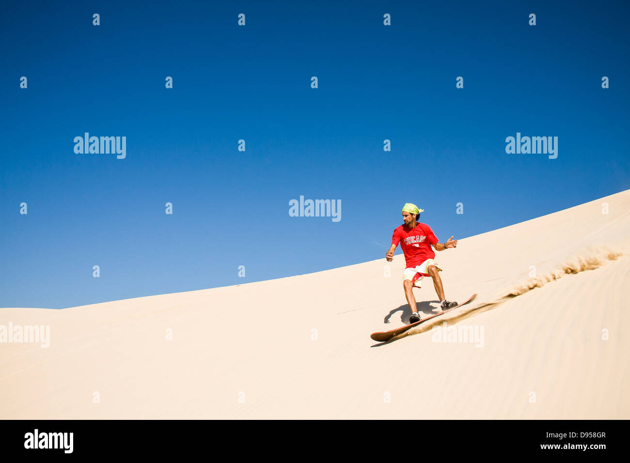 Adult man sandboarding on the dunes of Siriu Beach, in Garopaba ...