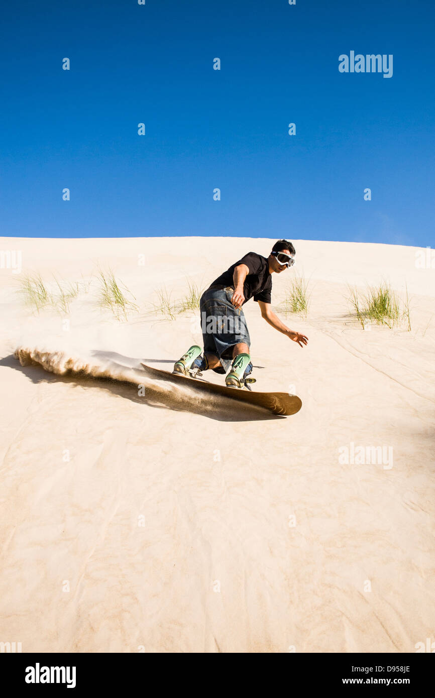 Adult man sandboarding on the dunes of Rio Vermelho State Park Stock ...