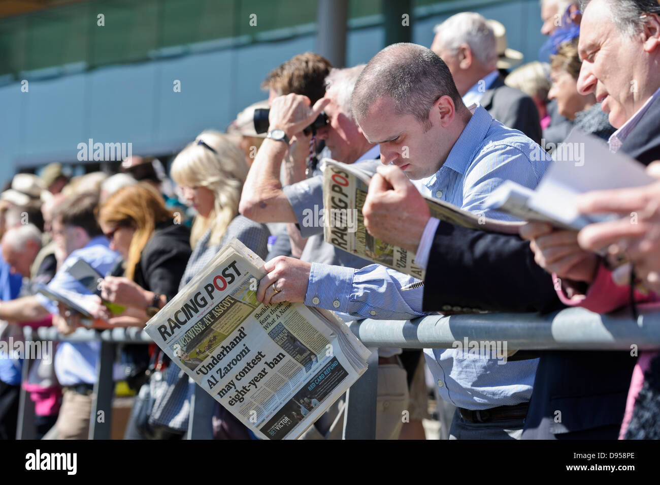 Visitors reading the Racing Post newspaper at Ascot Racecourse, England ...