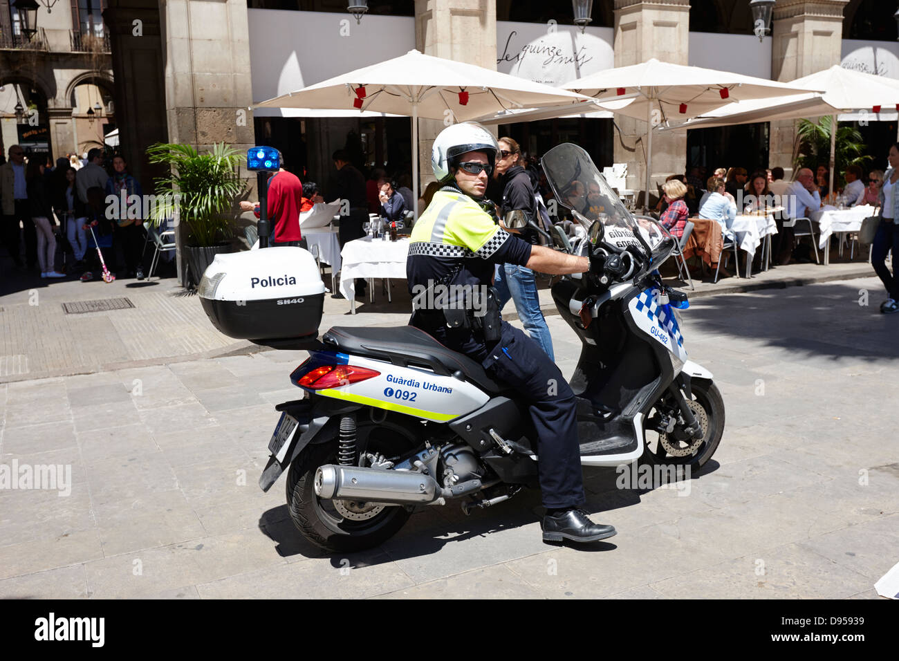 guardia urbana police officer on scooter patrolling placa reial city ...