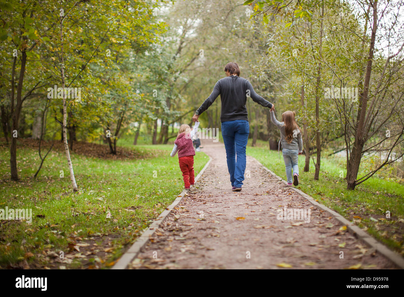 Back view of father and his two little daughters outdoor Stock Photo ...