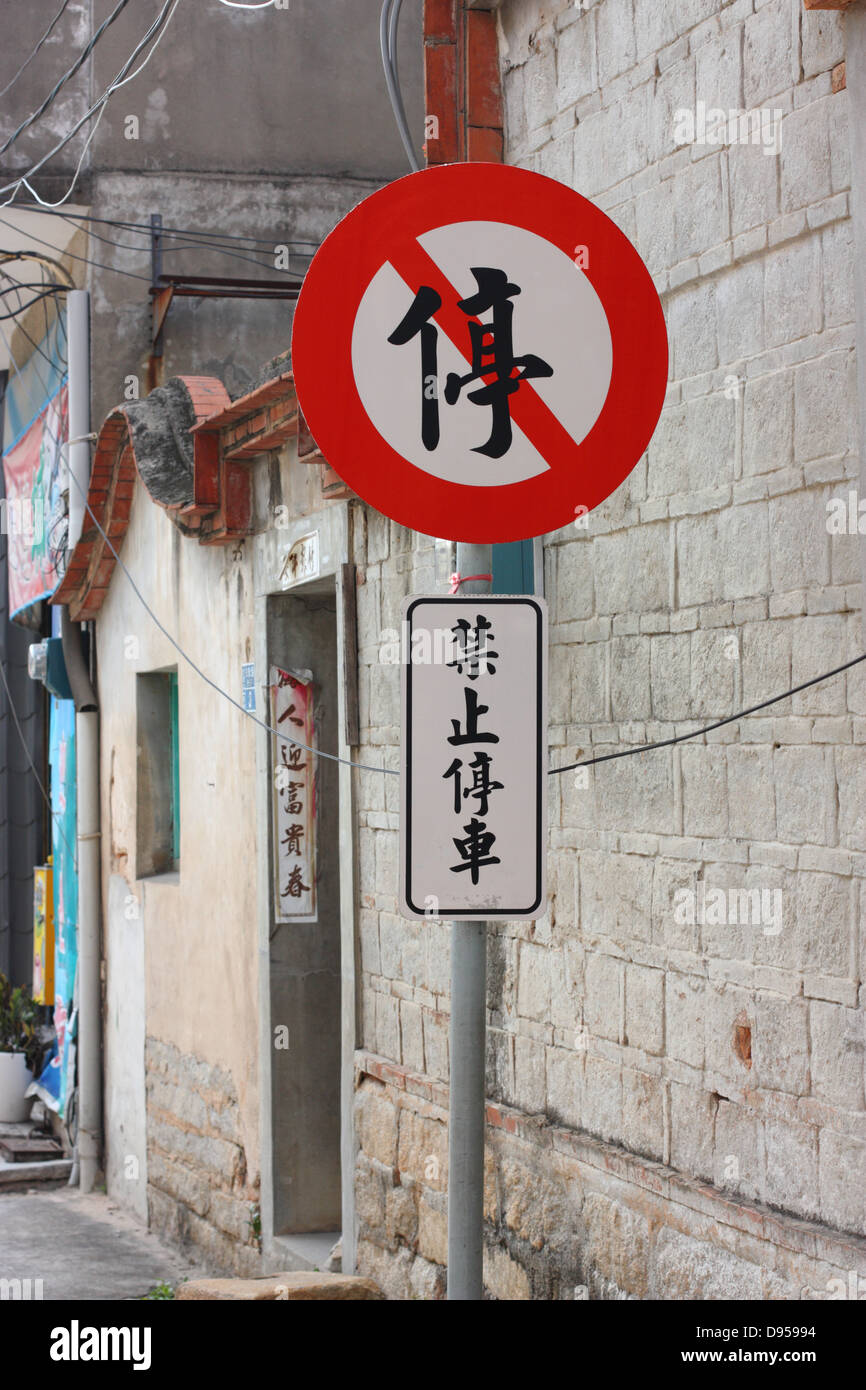 A stop sign in front of an old saddleback style house. Jincheng, Kinmen ...