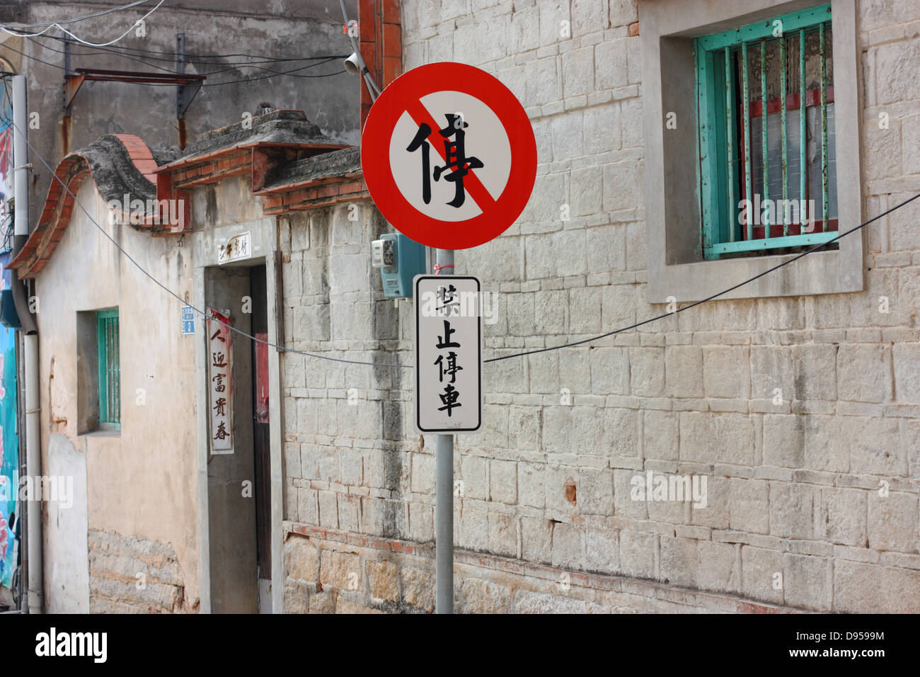 A stop sign in front of an old saddleback style house. Jincheng, Kinmen ...