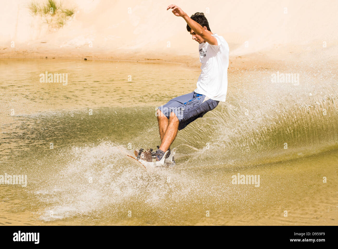 Young man sliding on water with a sandboard Stock Photo - Alamy