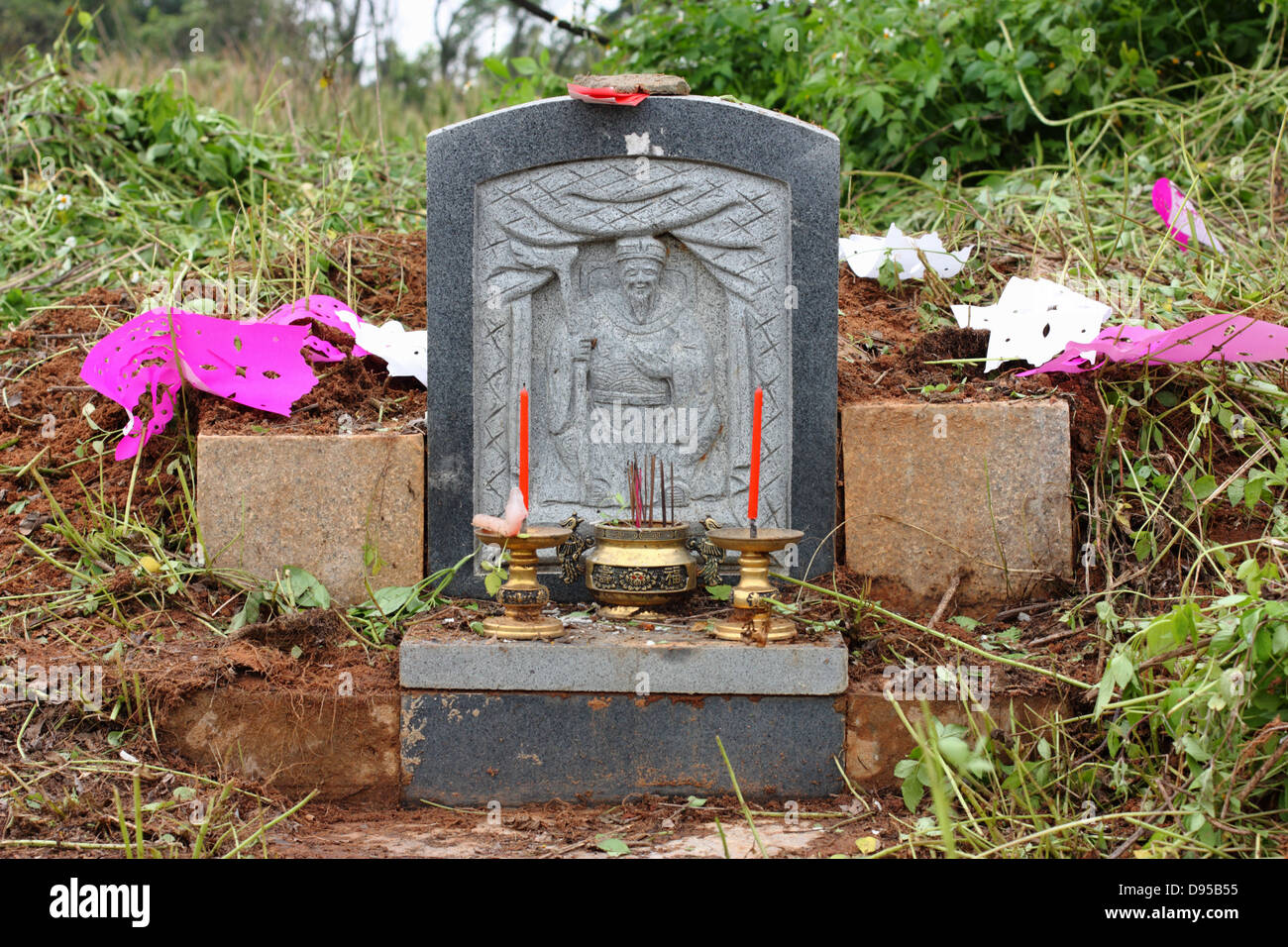 An overgrown gravesite cleaned up and decorated for Tomb Sweeping ...