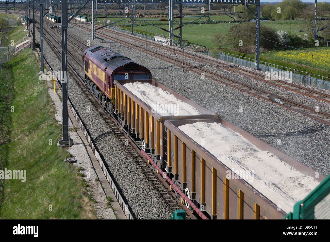 A cargo of sand blows from the back of a freight train on the West ...