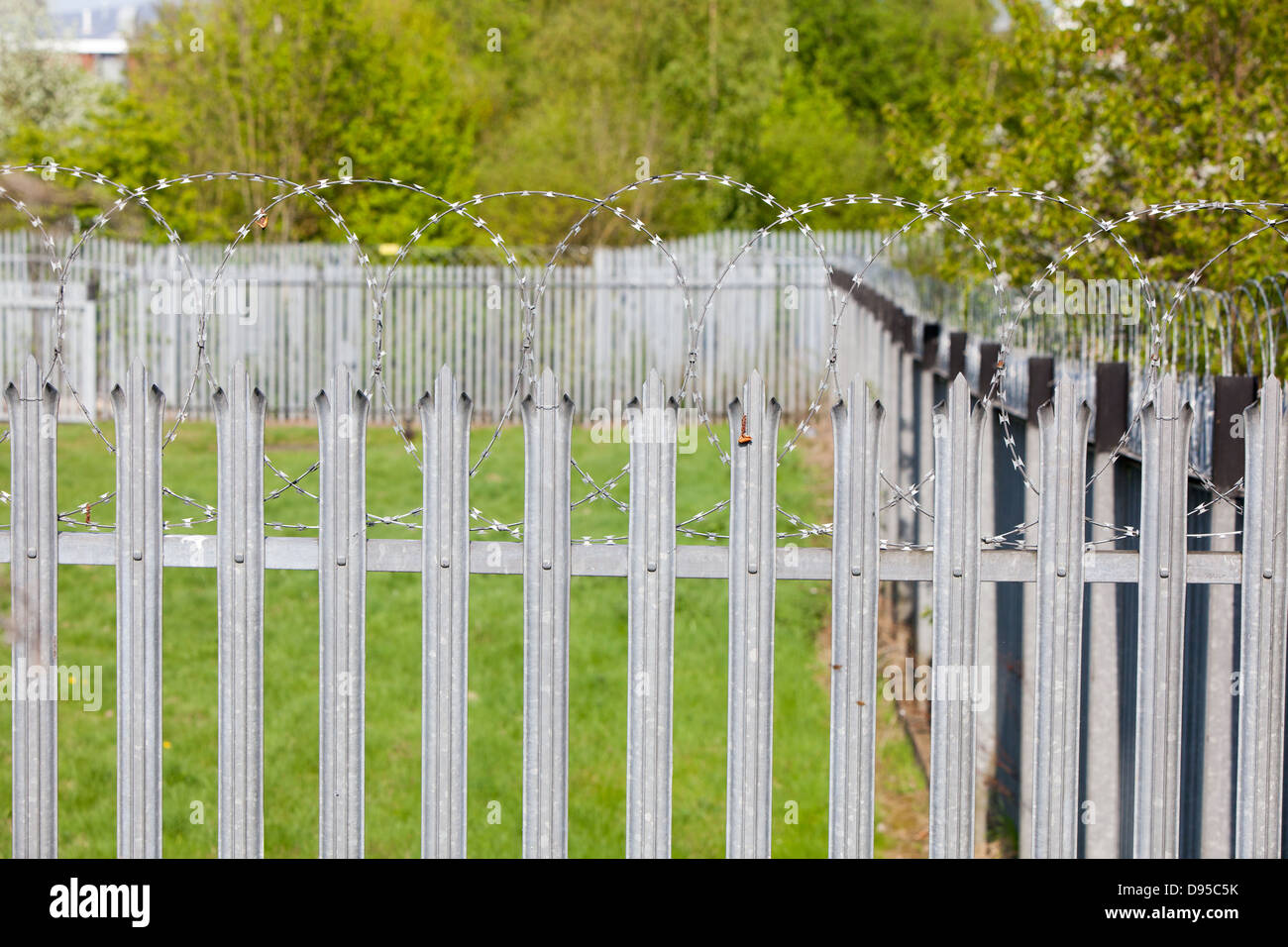 Spiked metal railings and razor wire around a secure compound Stock ...