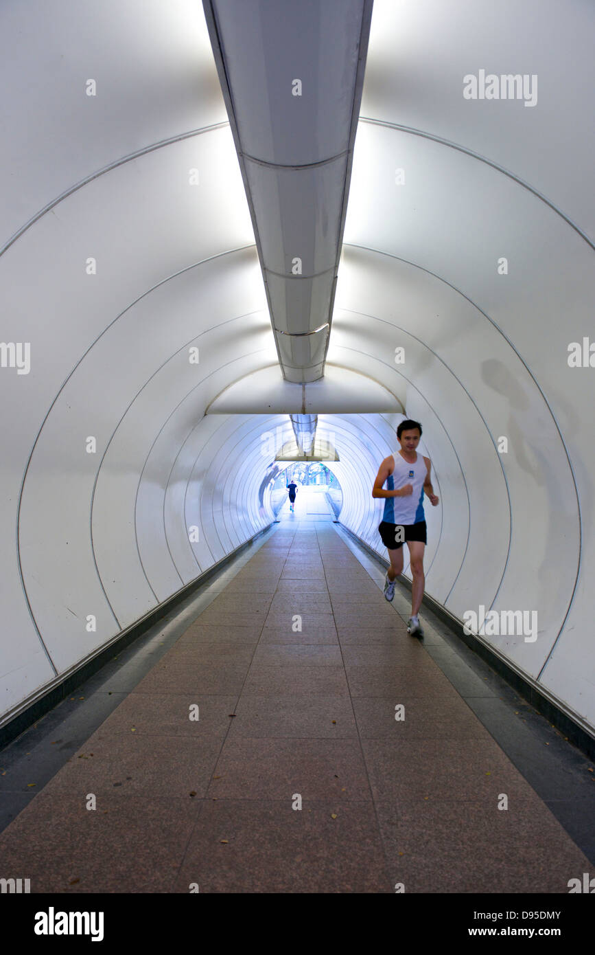 Man running through a tunnel in Singapore Stock Photo - Alamy