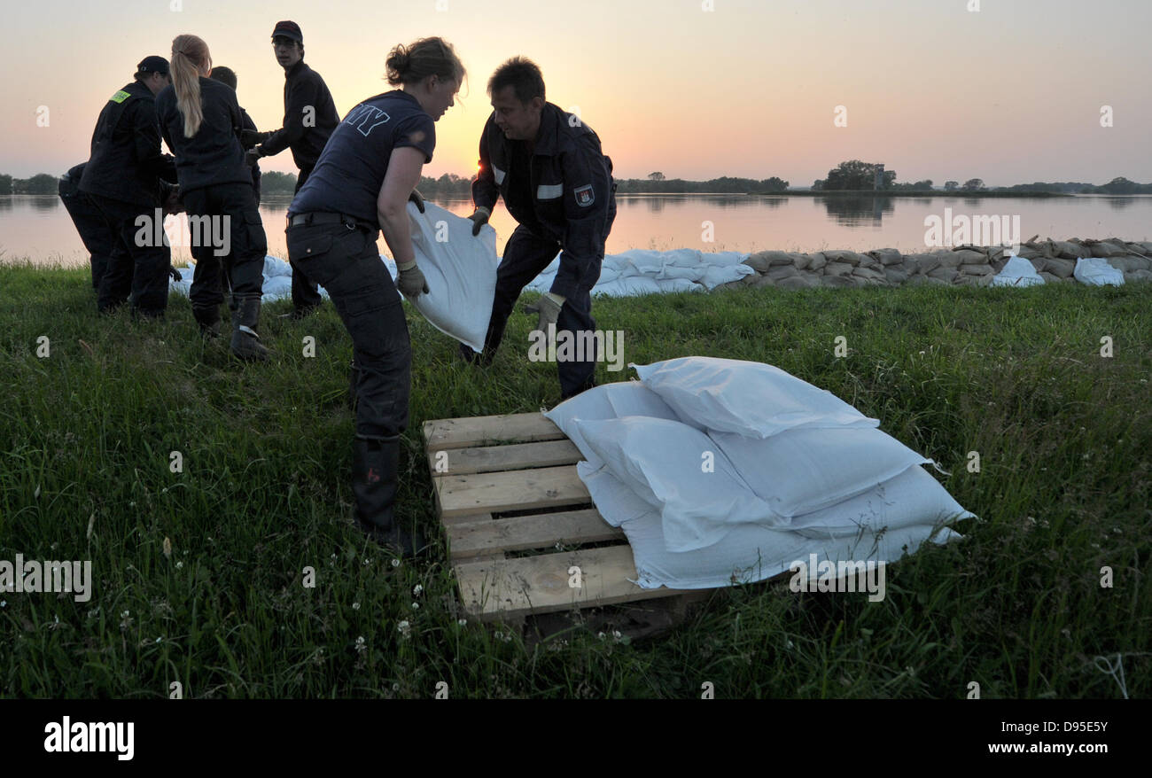 Helpers of the fire department build a wall of sandbags on a dike near ...