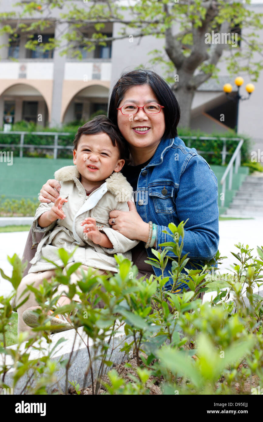 An elementary school teacher poses with a mixed race 2 year old boy ...