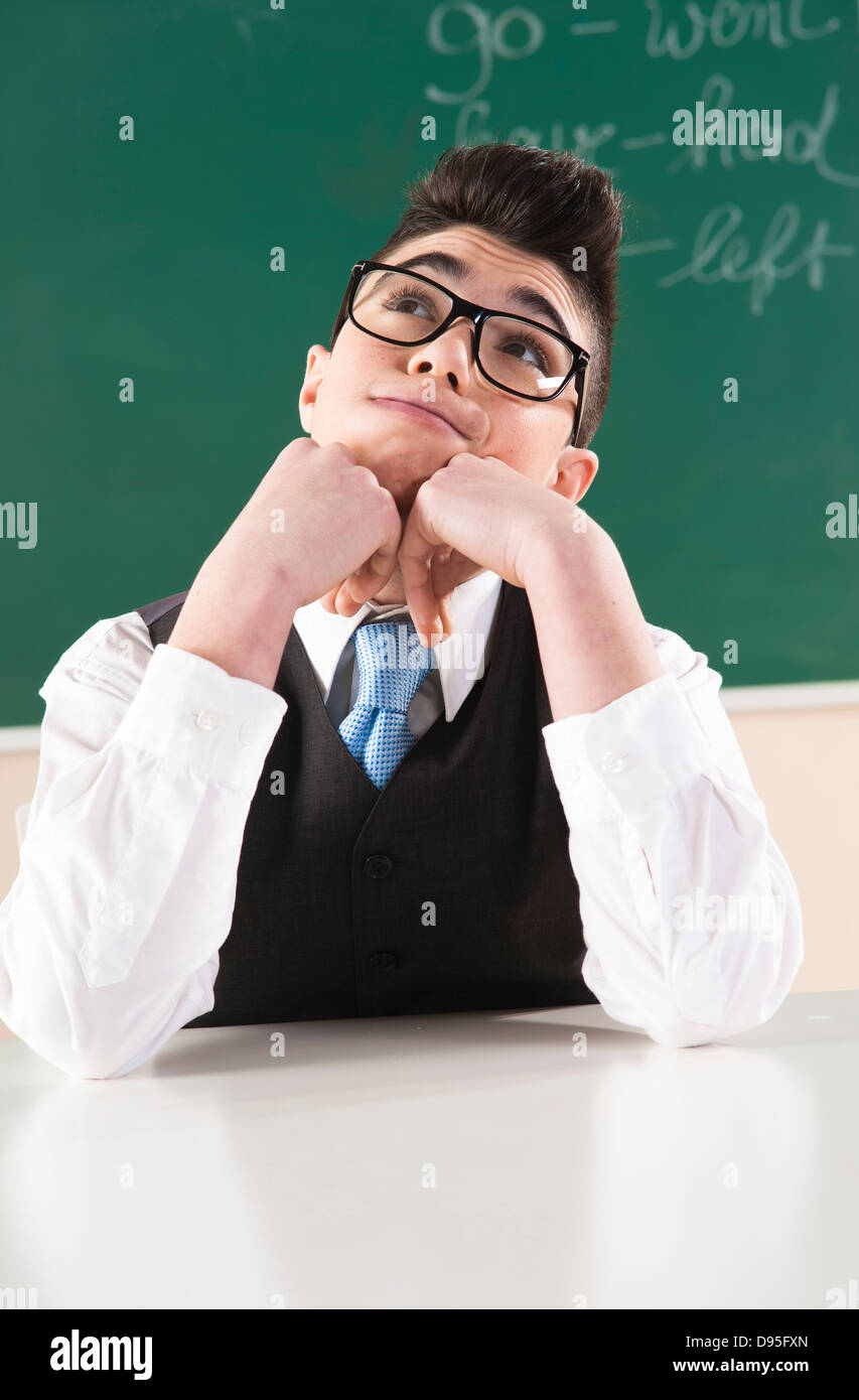 Boy Leaning on Hands in front of Chalkboard in Classroom Stock Photo ...