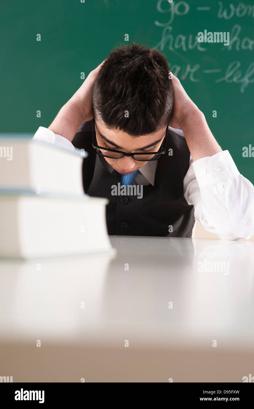 Boy with Hands on Head and Looking Down in Classroom Stock Photo - Alamy