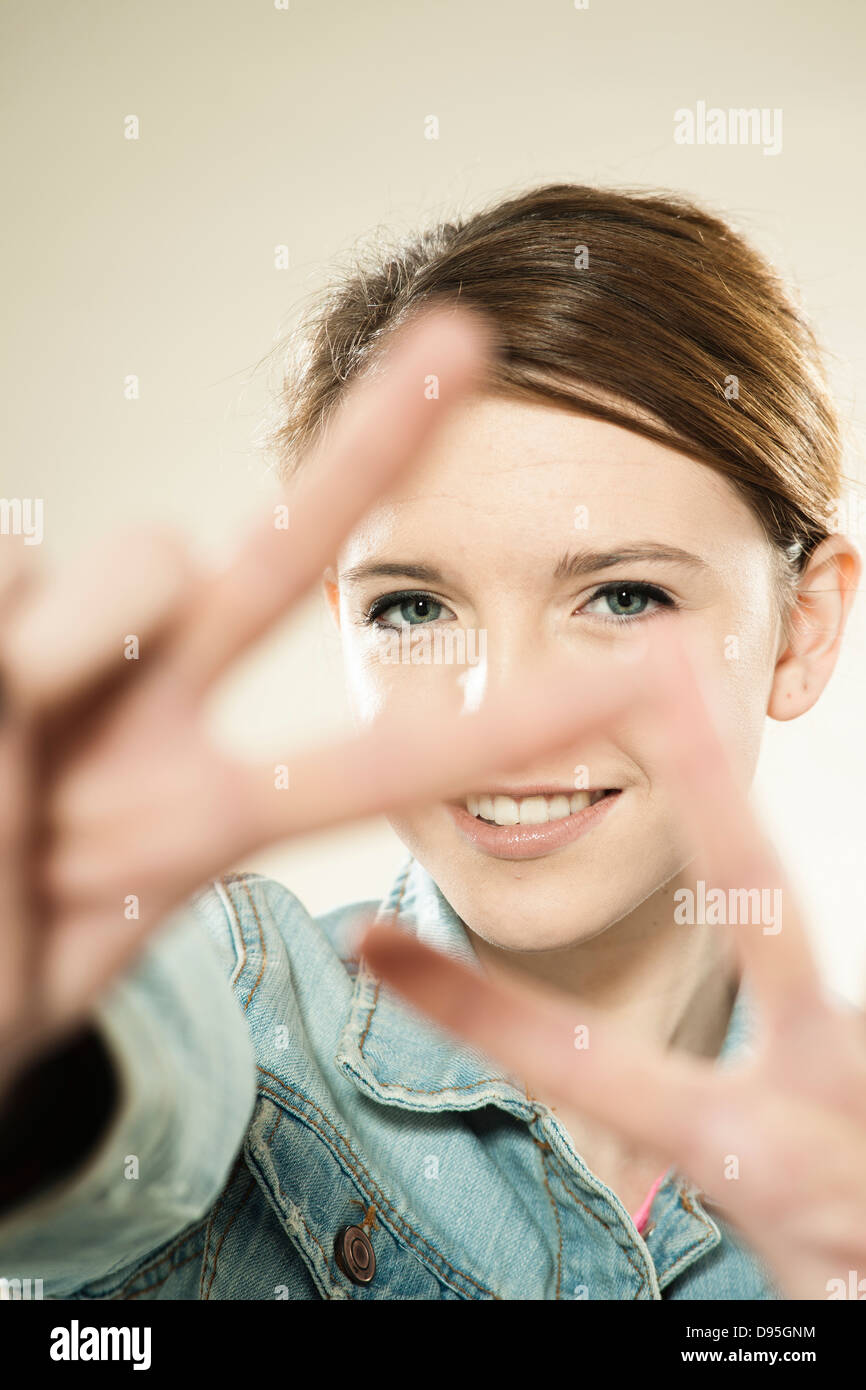 Portrait of Teenage Girl Making the Peace Sign with Her Fingers, in ...