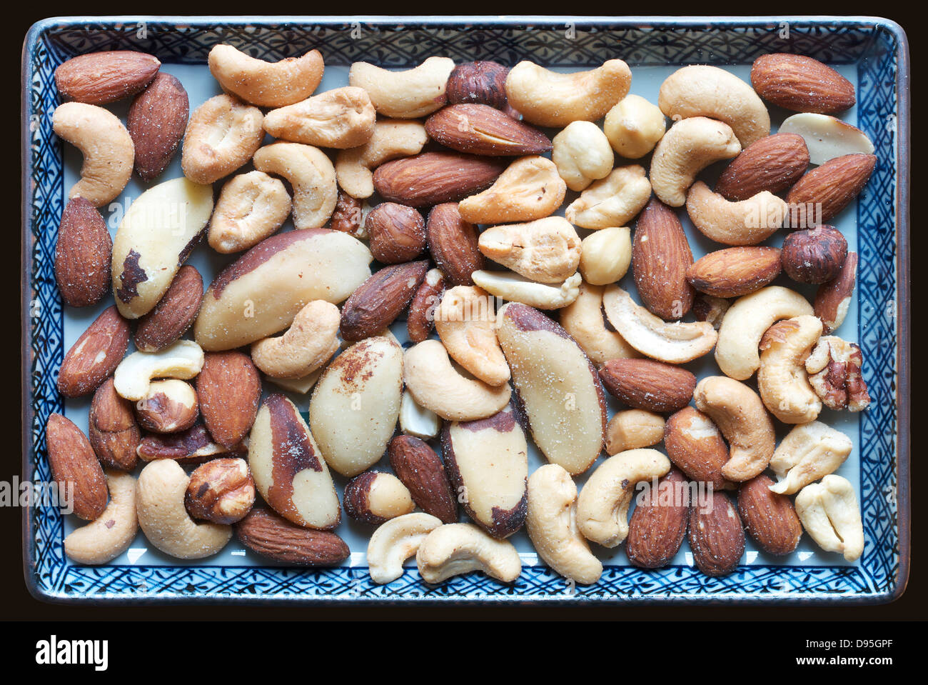 Rectangular plate with roasted, salted nuts Stock Photo - Alamy
