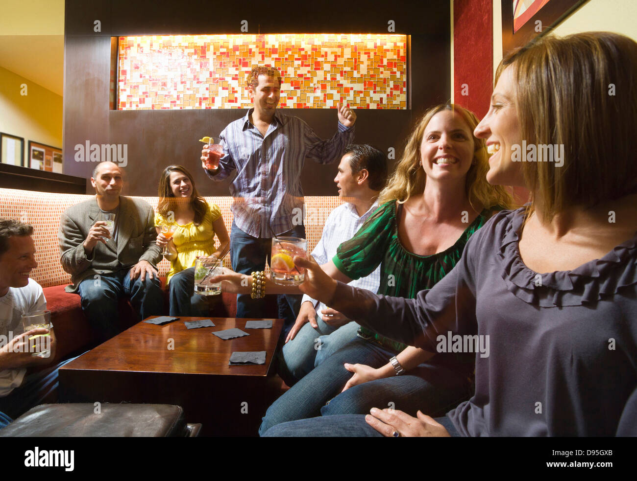 Men and women socializing in a bar in the city. Group of festive ...