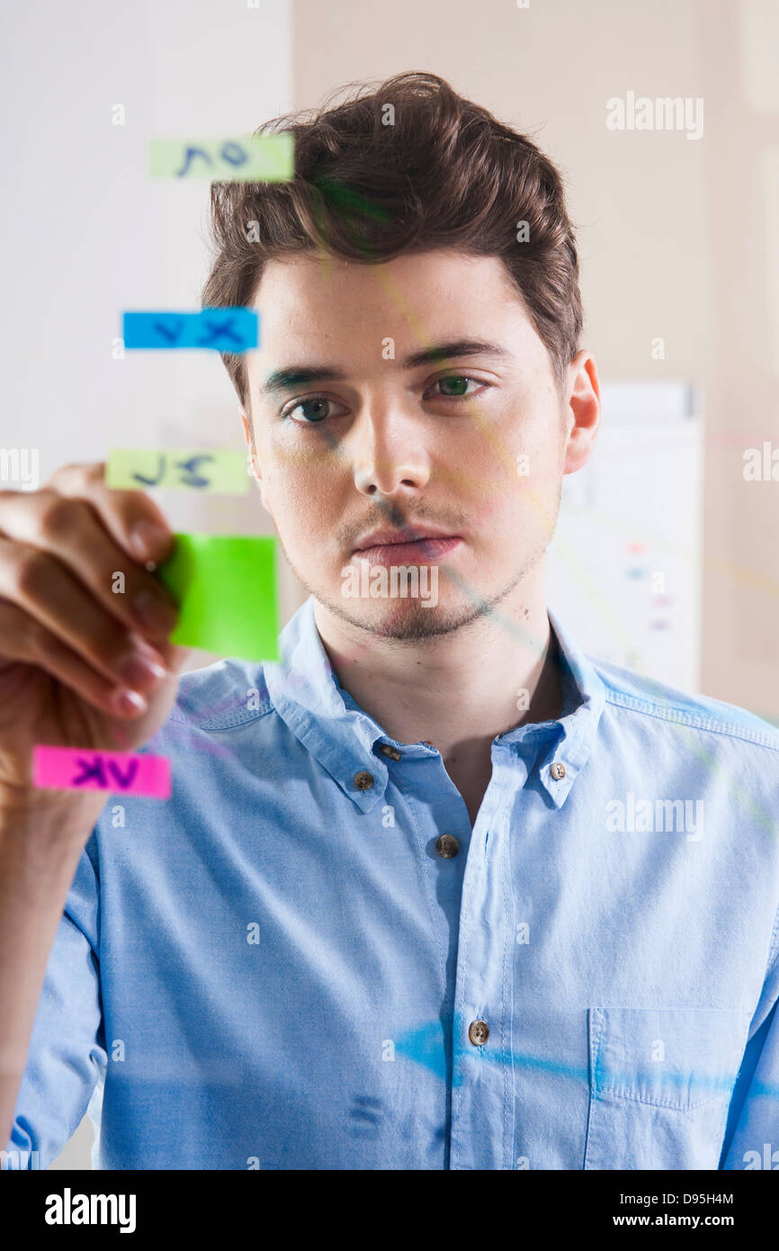Young Man Working in an Office, Looking Through Glass Board, Germany ...