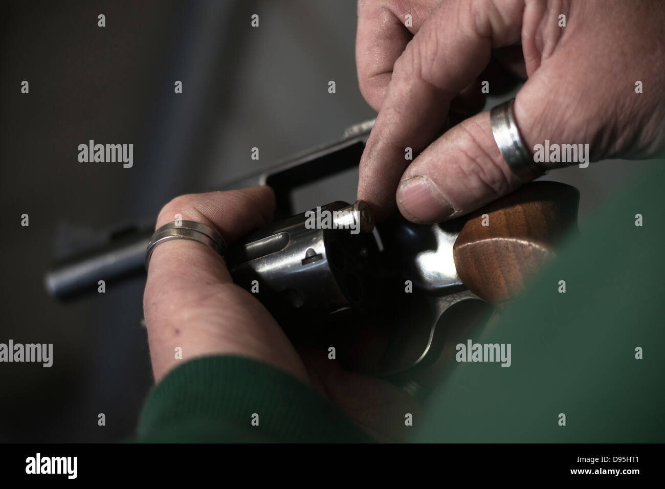 Close-up of Man Loading Bullets into Gun, Mannheim, Baden-Wurttemberg ...