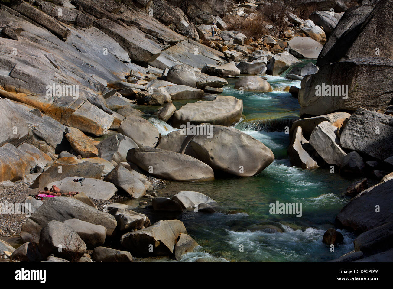 Man and woman sunbathing on rocks by Yuba river in central valley ...