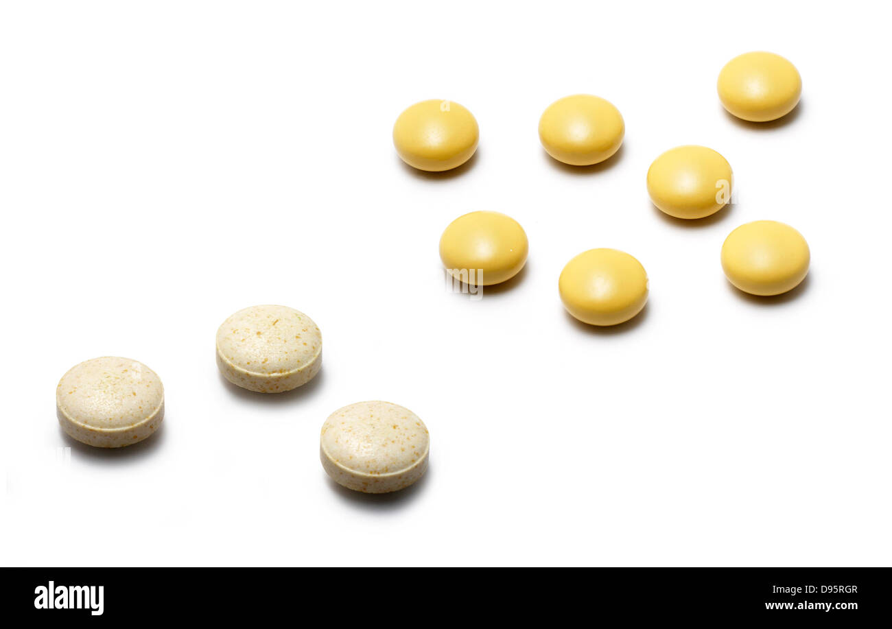yellow pills cut out onto a white background Stock Photo - Alamy