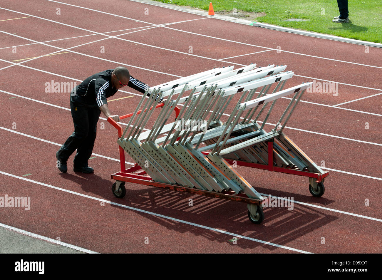Athletics, man moving hurdles Stock Photo - Alamy