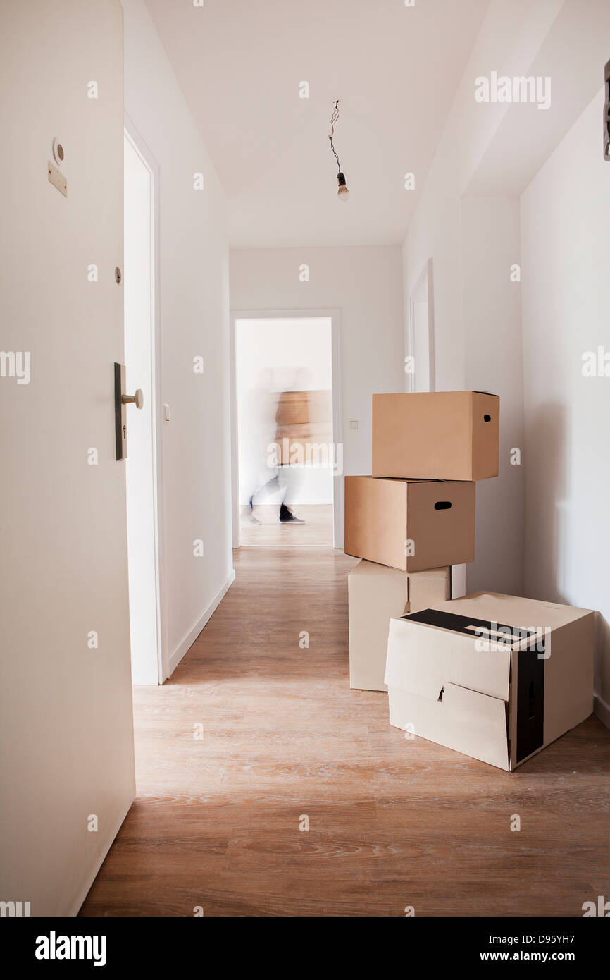 Cardboard boxes on corridor while man walking in background Stock Photo ...