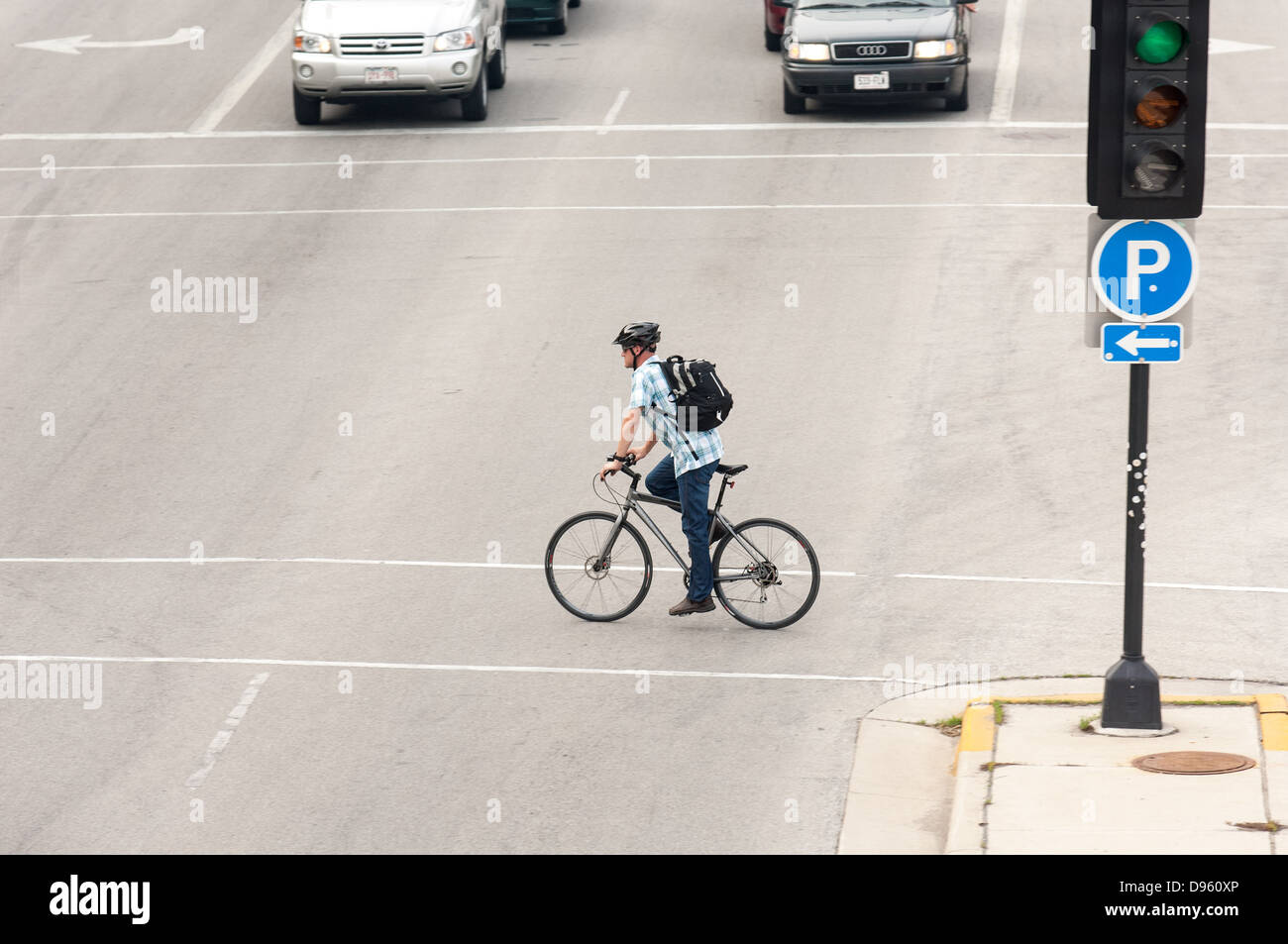 Bicycle commuter crossing intersection Stock Photo - Alamy