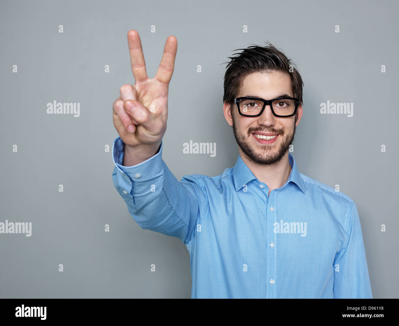 Businessman doing peace sign, smiling Stock Photo - Alamy