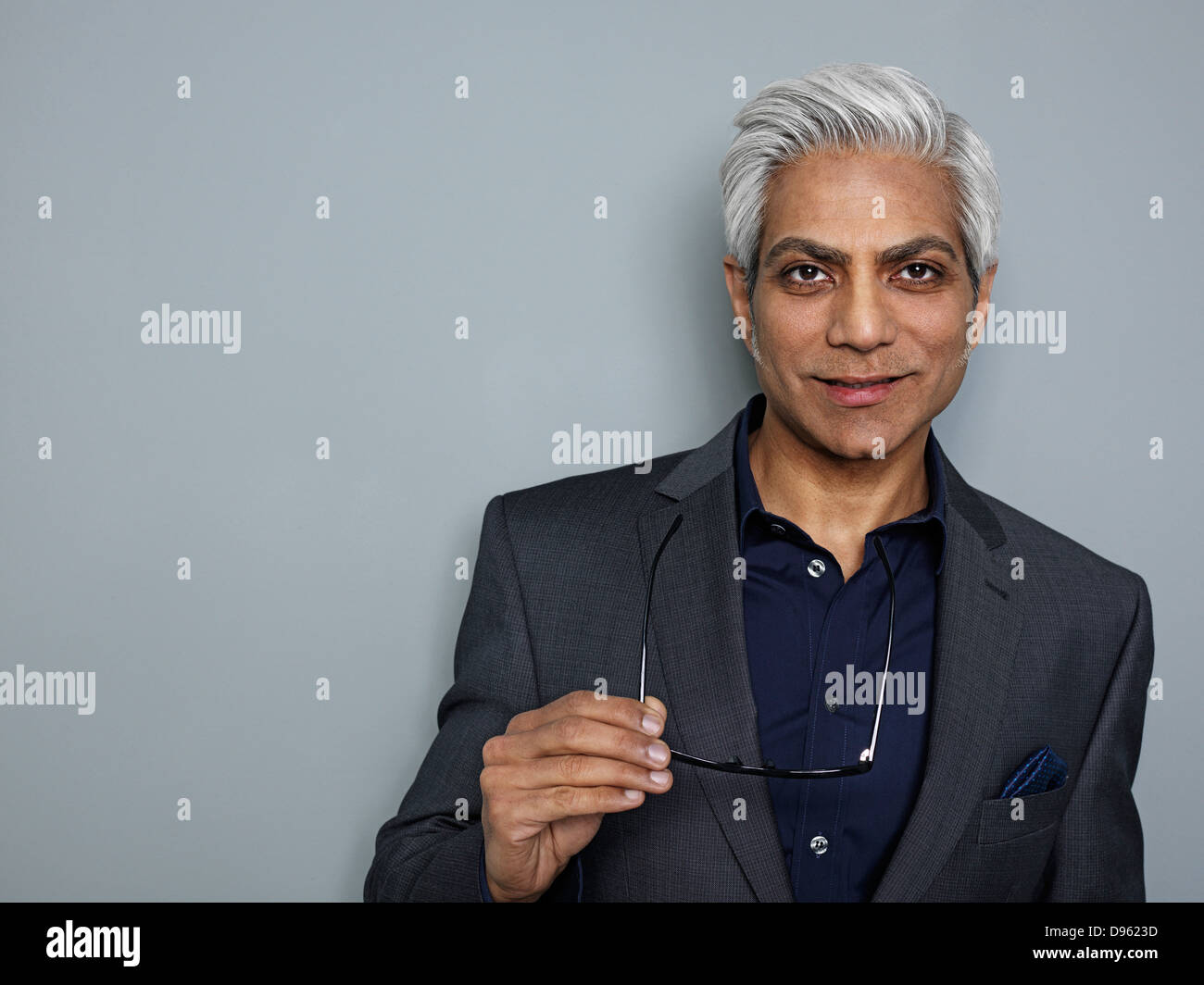 Businessman holding spectacles, portrait Stock Photo - Alamy