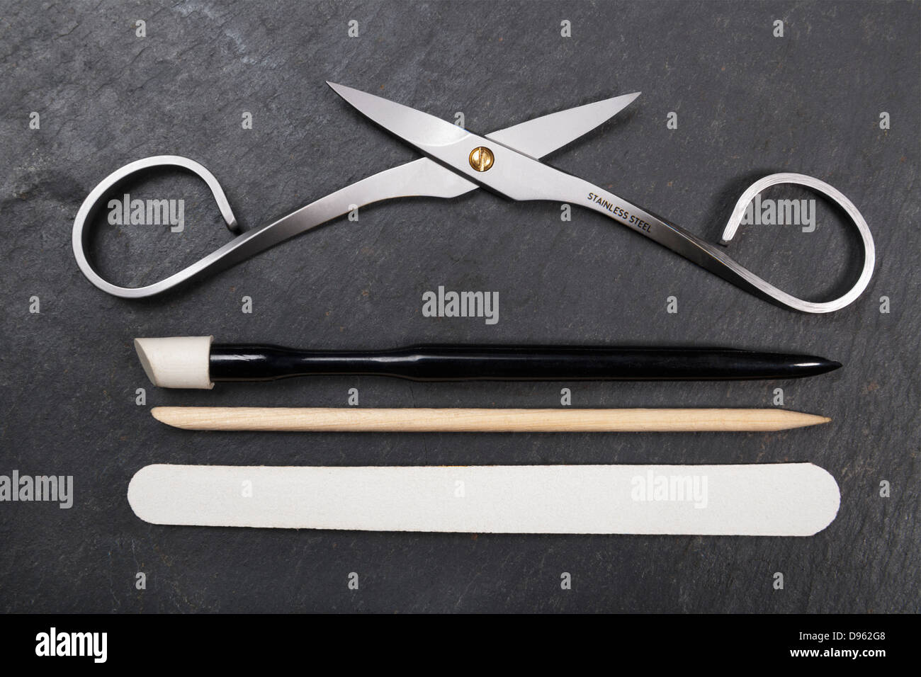 Nail scissors, emery board and other nail care uthensils on slate board ...