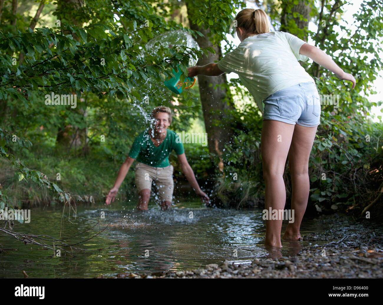 Austria, Teenage girl and boy splashing water in stream Stock Photo - Alamy