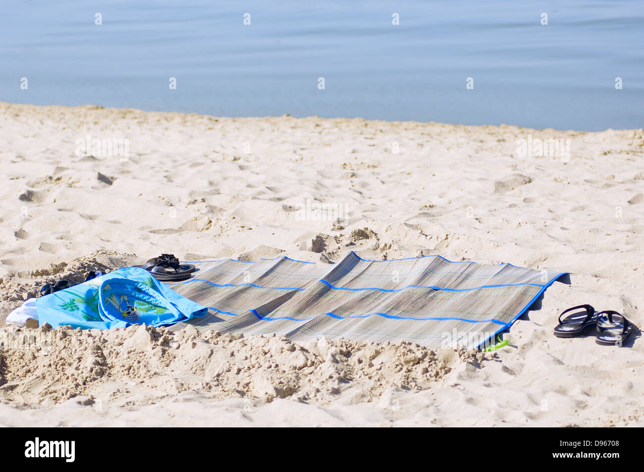 Summer carpet with bag, and flip flops on sandy beach Stock Photo - Alamy