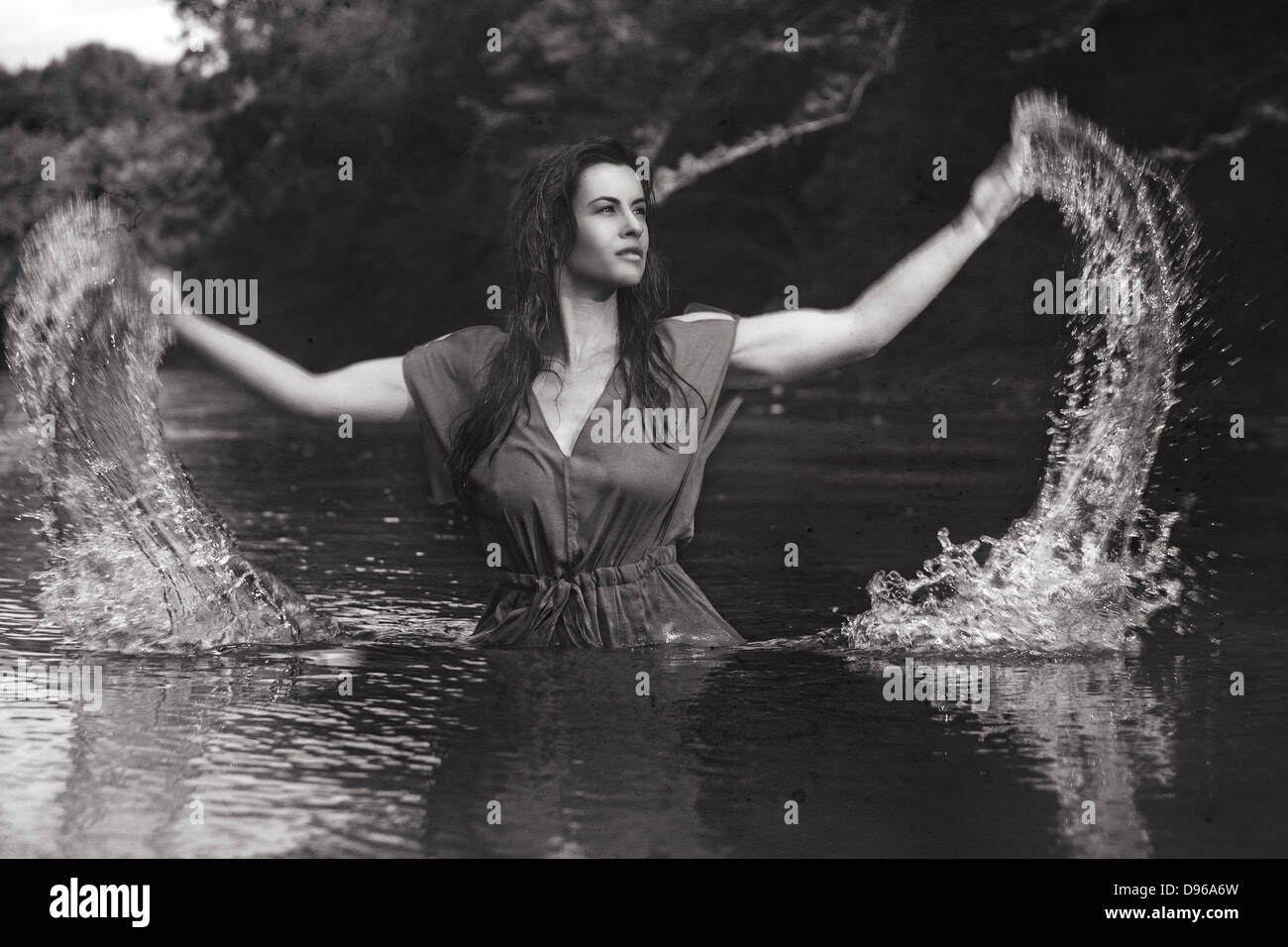 Woman splashing water out of river Stock Photo - Alamy