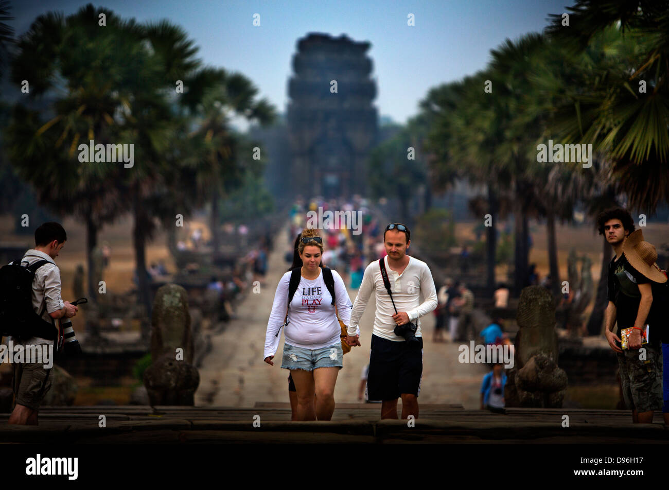 Crowds of tourists arriving at dawn in Angkor Wat temple, Cambodia ...