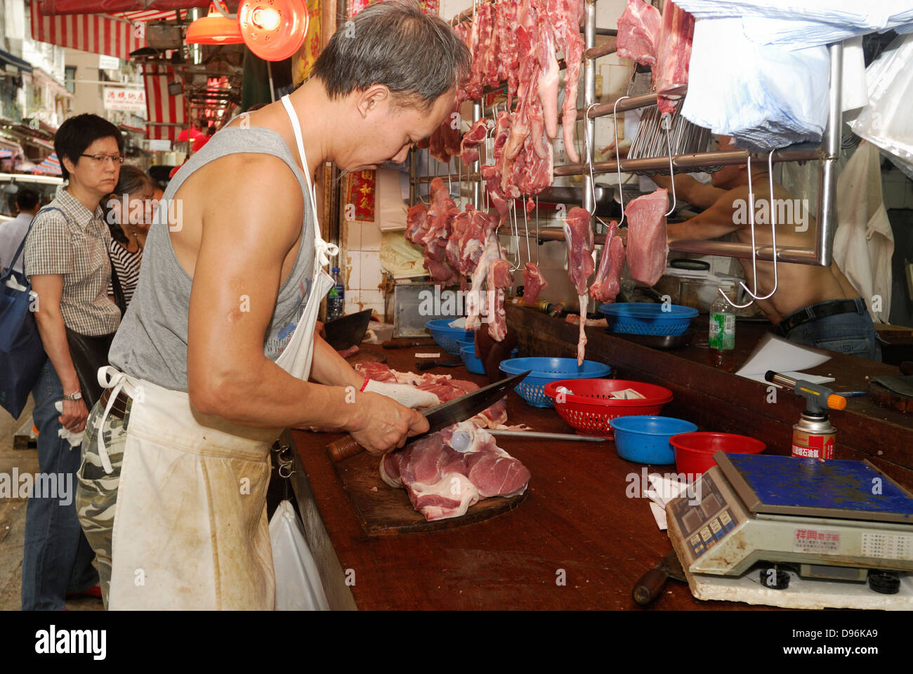 Butcher cutting meat in outdoor street market, Hong Kong China Stock ...
