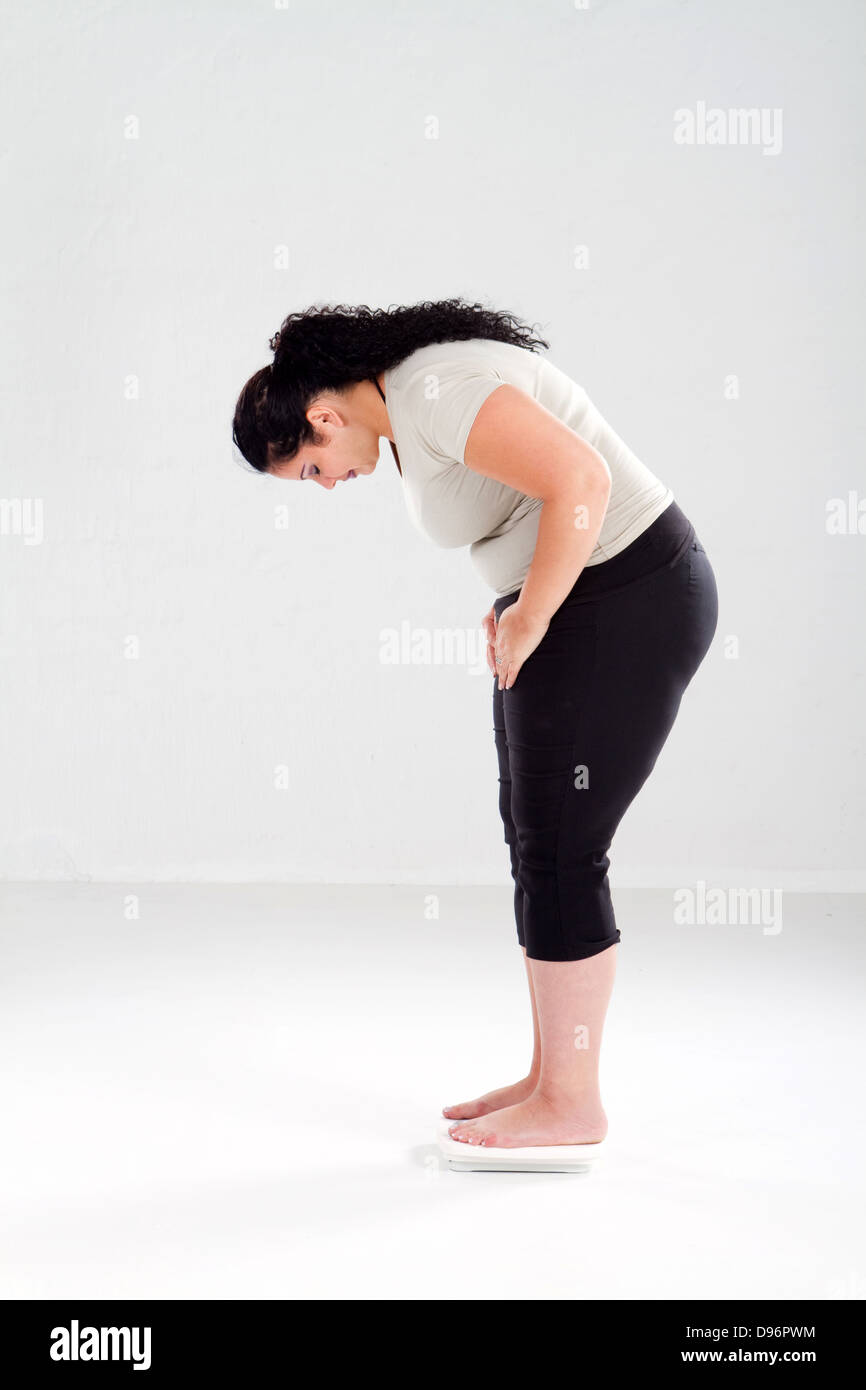 overweight woman standing on scale Stock Photo - Alamy