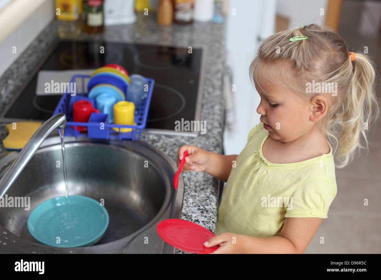 Little girl playing in the kitchen Stock Photo - Alamy