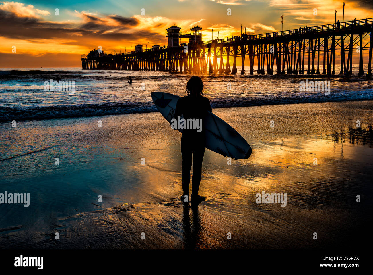 Surfer at sunset Stock Photo - Alamy