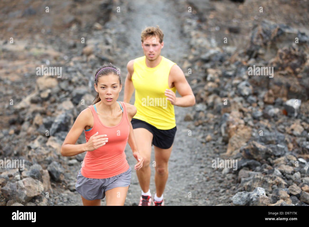 Runners couple running on trail in cross country run outdoors training ...