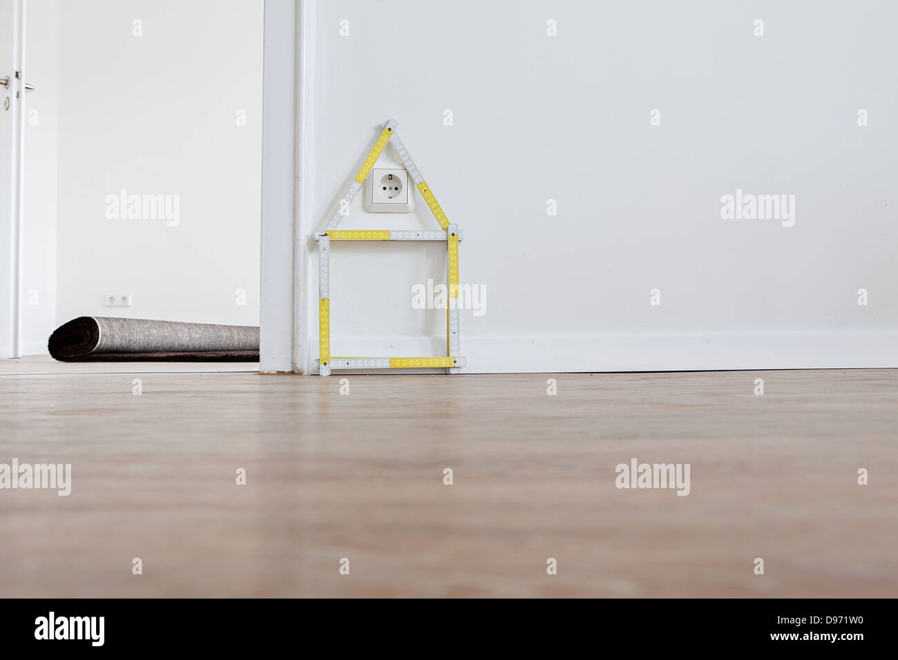 Folded ruler in house shape on wall with wallpaper Stock Photo - Alamy