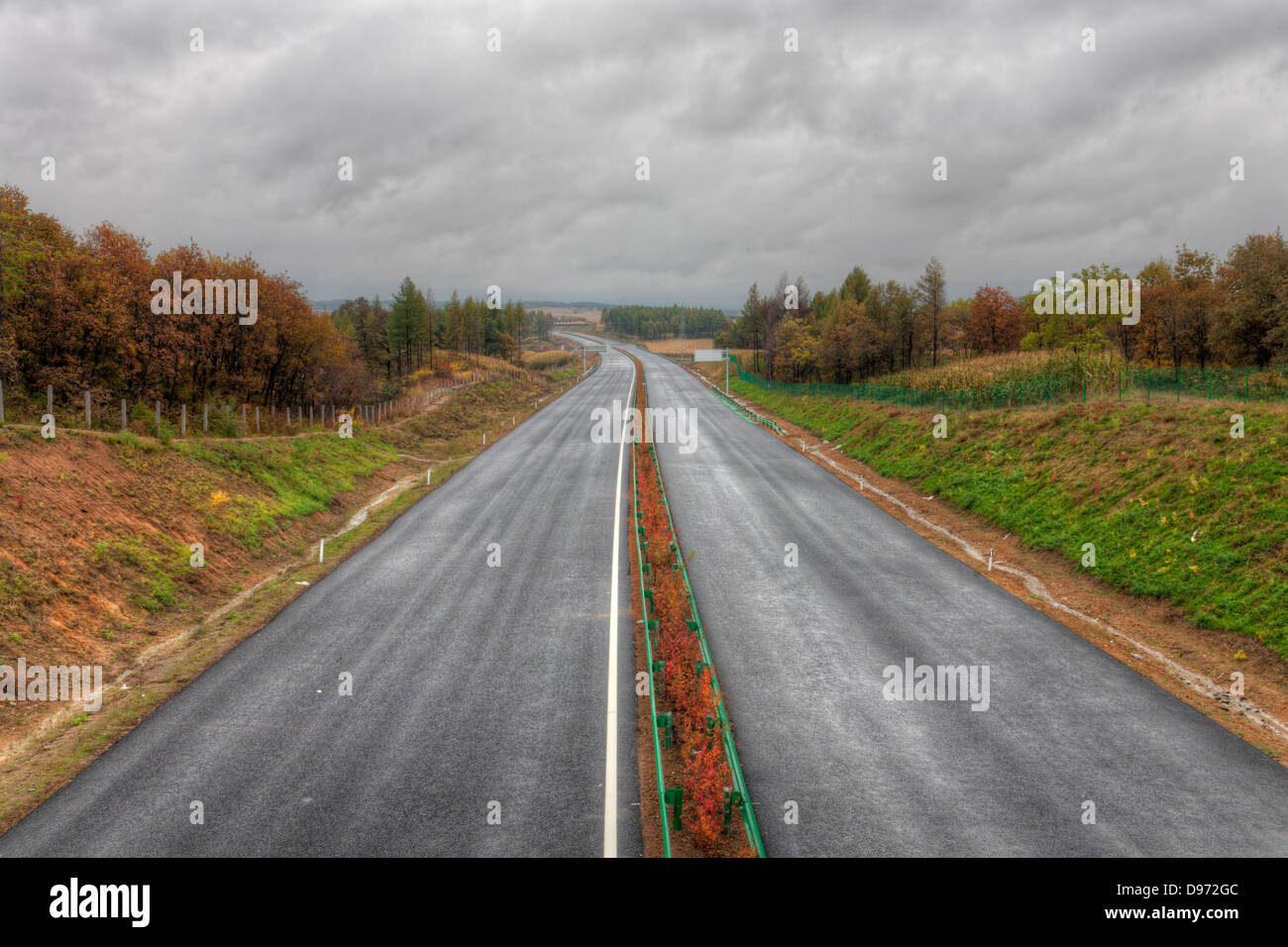 Highway through bushes and woods Stock Photo - Alamy