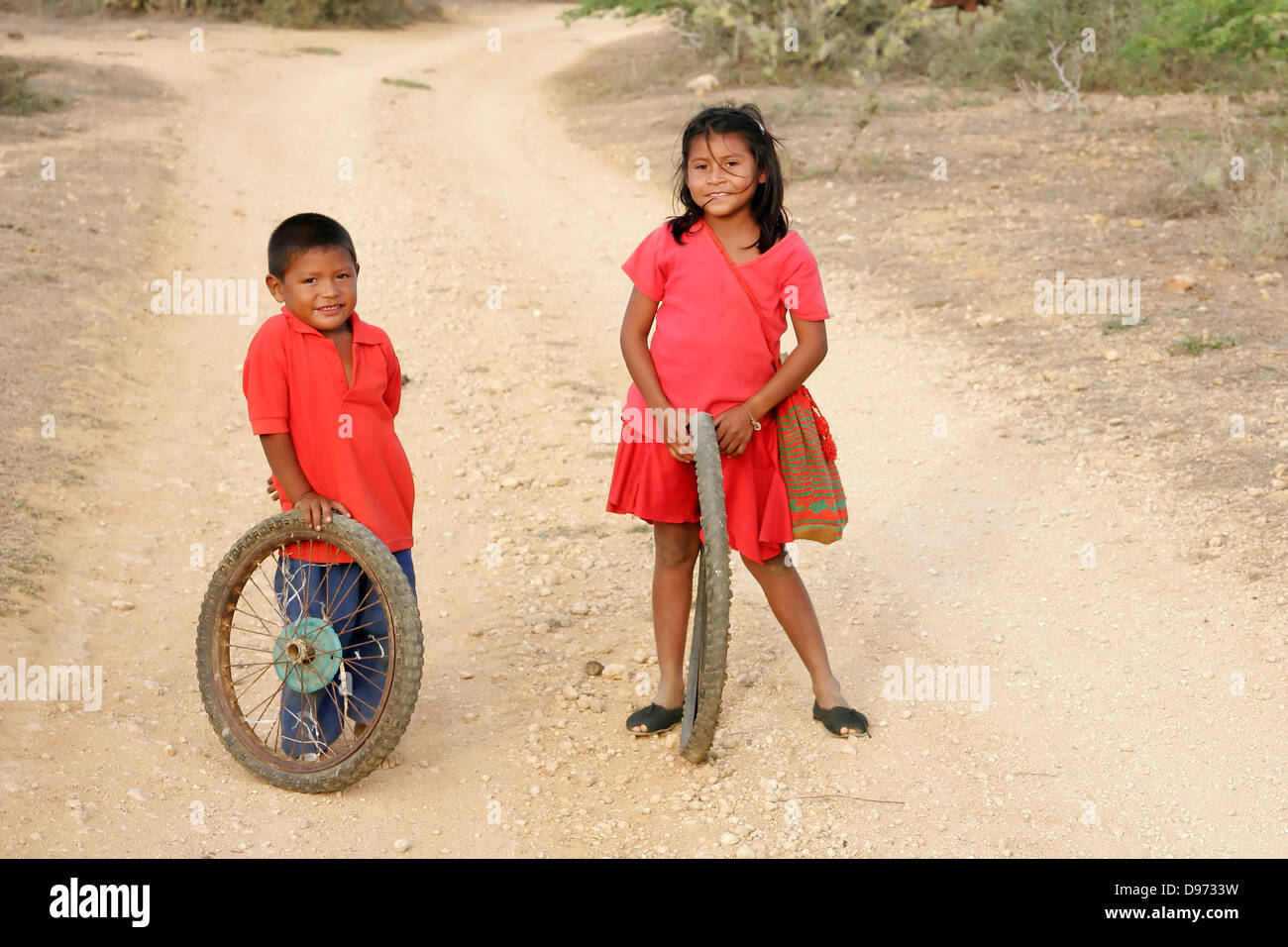 Indigenous Wayuu kids playing on the road with bicycle wheels, Punta ...