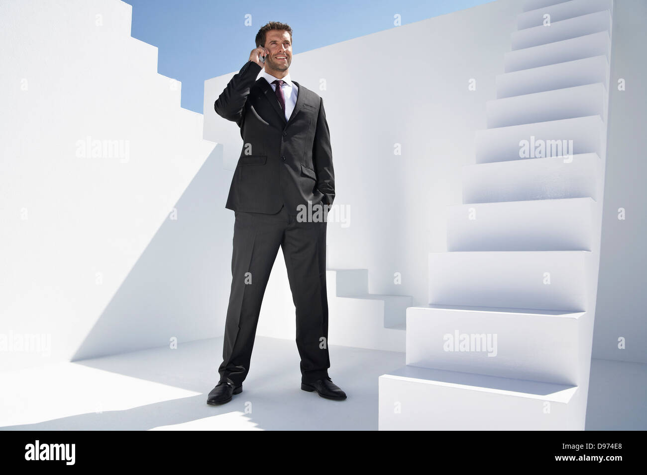 Businessman in black suit talking on mobile phone, smiling Stock Photo ...