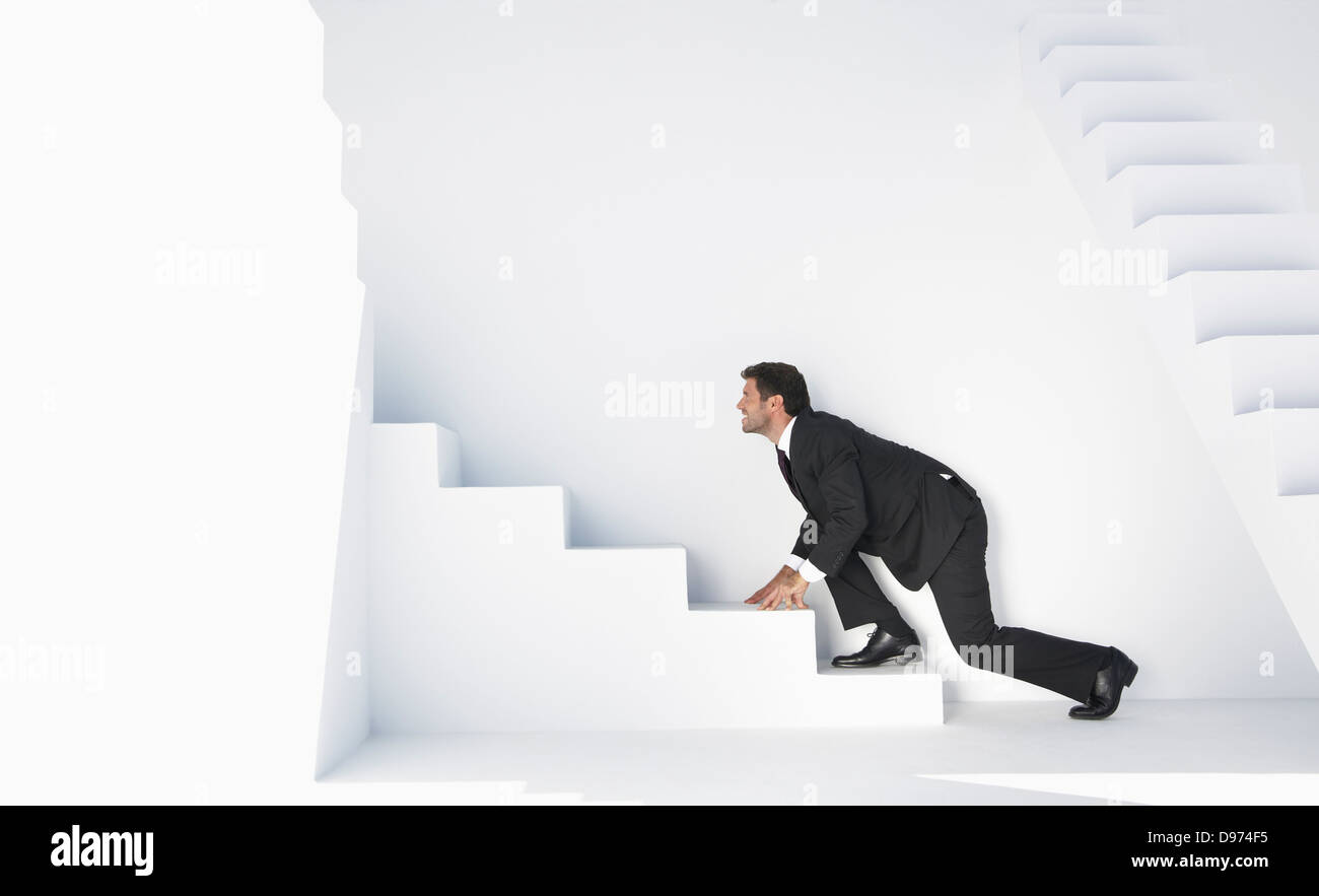 Businessman in black suit moving up stairs Stock Photo - Alamy