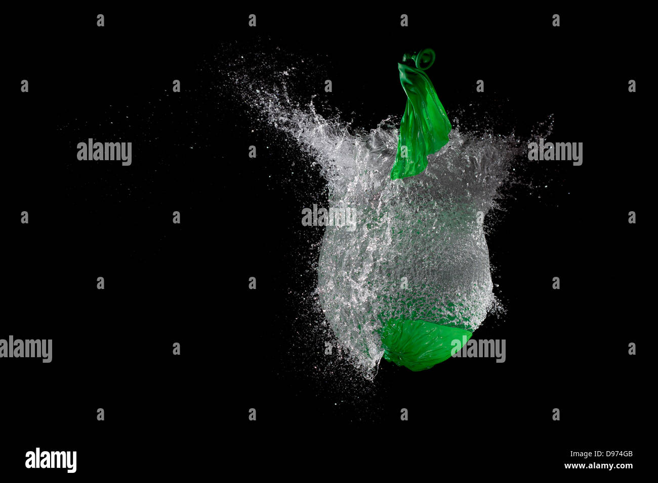 Green waterballoon bursting against black background, close up Stock ...