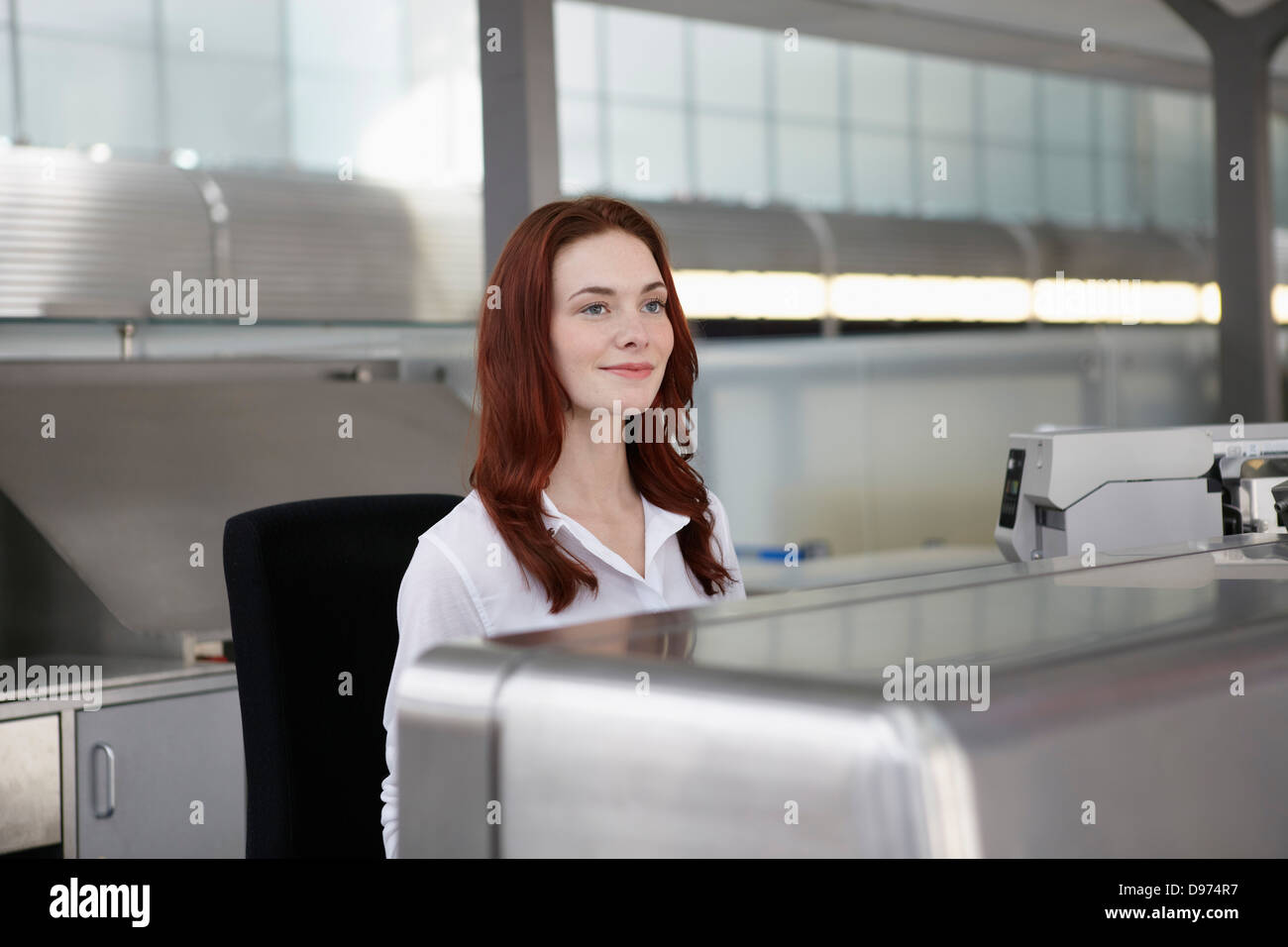Germany, Cologne, Young woman at ticket counter Stock Photo - Alamy