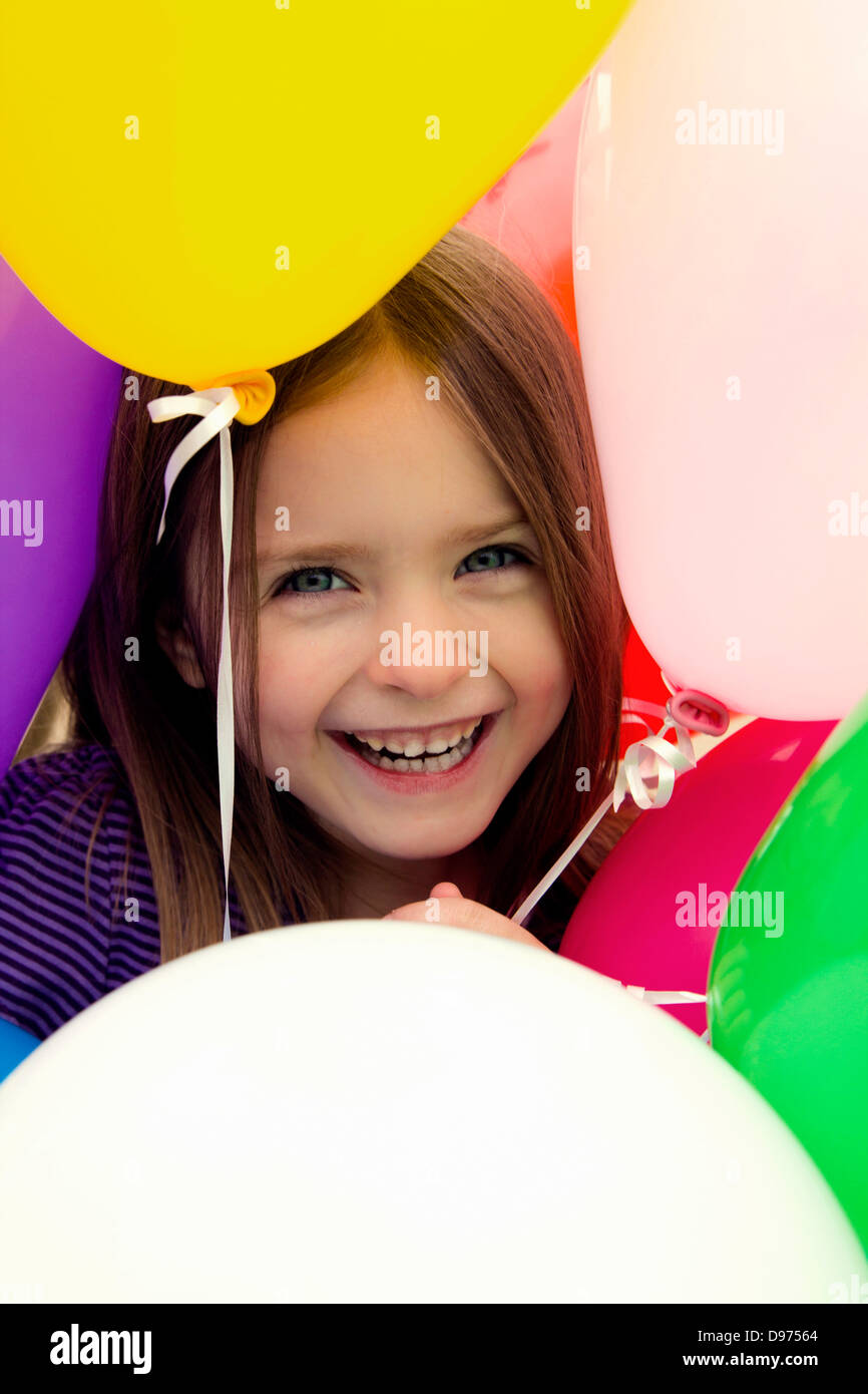 Portrait of girl in middle of balloons, smiling Stock Photo - Alamy
